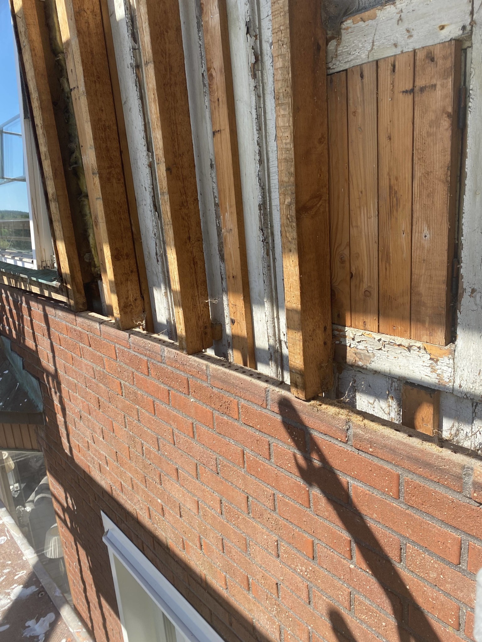 Stående panel takspets mot tegelfasad | Byggahus.se